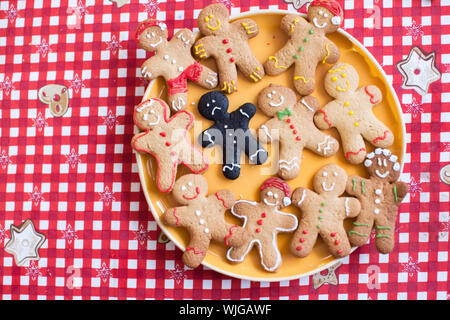 Sad burnt gingerbread man among finished with colored glaze Stock Photo ...