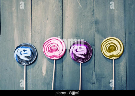 Photo of pink and yellow lollipops on wooden background Stock Photo - Alamy