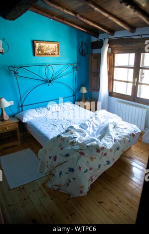 bed at a lonely bedroom with blue wall Stock Photo - Alamy