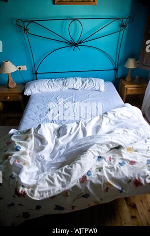 bed at a lonely bedroom with blue wall Stock Photo - Alamy