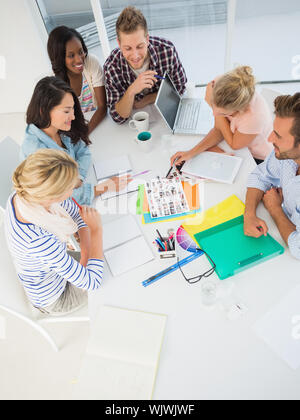 Creative team going over contact sheets in meeting in office with ...