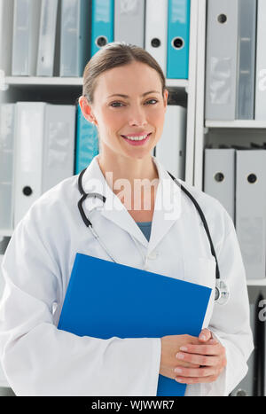 Beautiful female doctor with folders in clinic Stock Photo - Alamy