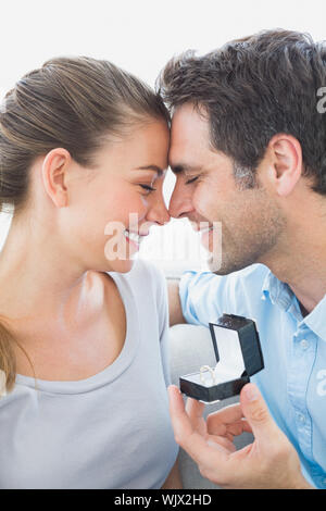 Happy couple getting engaged on the sofa Stock Photo - Alamy