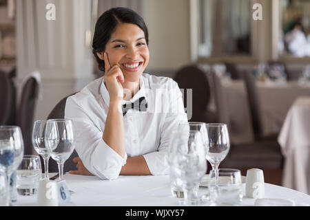Pretty waitress sitting at set table in a fancy restaurant Stock Photo ...