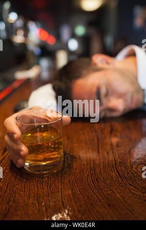 Drunk businessman slumped on bar beside cocktail at the local bar Stock ...