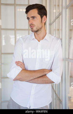 Casual upset businessman leaning against window Stock Photo - Alamy