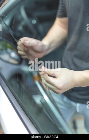 Tinted dark glass foil removal from car window Stock Photo - Alamy