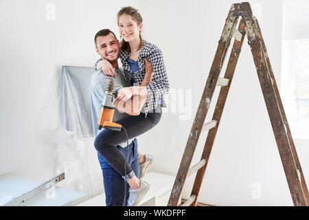 Cheerful couple renovate their new home with yellow color Stock Photo ...