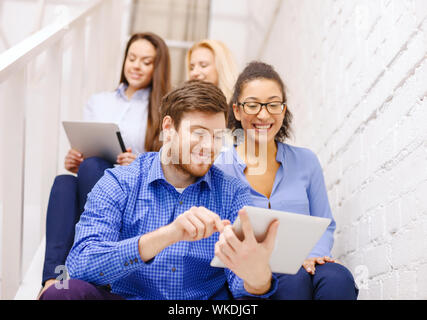 team with tablet pc computer sitting on staircase Stock Photo - Alamy