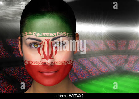 Composite image of beautiful iran fan in face paint against large ...