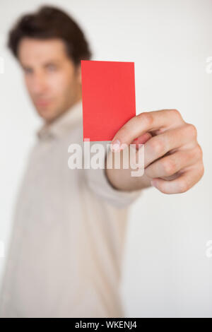 Casual businessman showing red card in the office Stock Photo - Alamy