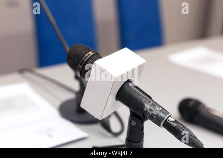 View of a black microphone on a table stand isolated on a white ...