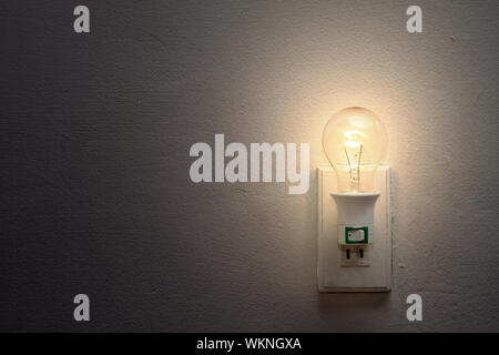 Weak light bulb and socket on the white wall Stock Photo - Alamy