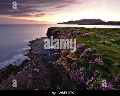 Sunset at Muckross Head, Co. Donegal with rocky shoreline dotted with ...