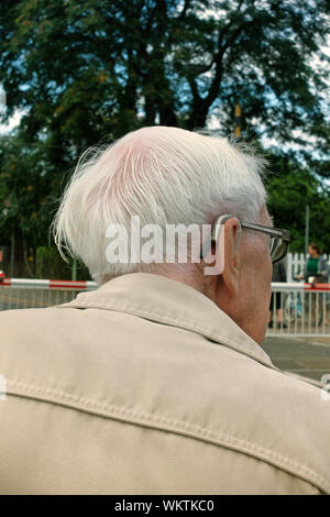 Senior grey-haired man wearing striped t-shirt standing over isolated ...
