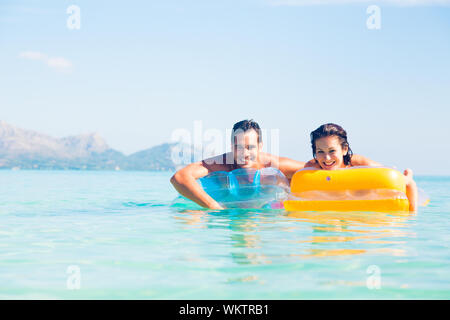 Couple floating on rafts on a Caribbean shore Stock Photo: 127234 - Alamy