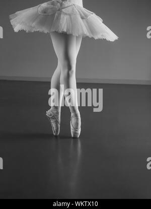 Gorgeous ballerina in a white tutu dancing ballet. Studio shooting on a ...
