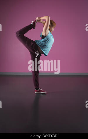 Pretty break dancer stretching leg behind head Stock Photo - Alamy