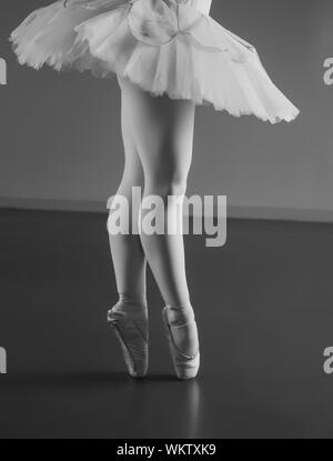 Gorgeous ballerina in a white tutu dancing ballet. Studio shooting on a ...