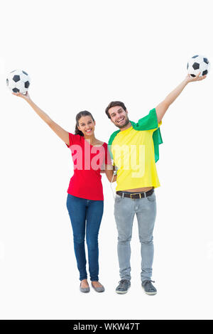 Excited beautiful couple wearing white t-shirts standing isolated over ...