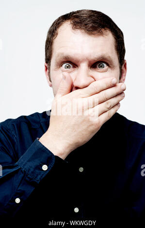 Caucasian surprised guy posing and covering his face isolated over grey ...