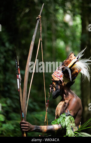 A group of Melanesian people in traditional white head dress holding ...