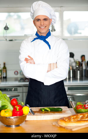 Chef with his arms folded and utensils Stock Photo - Alamy