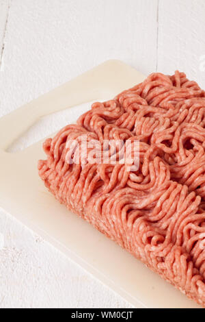 Block of fresh beef mince sliced through on a wooden cutting board with ...