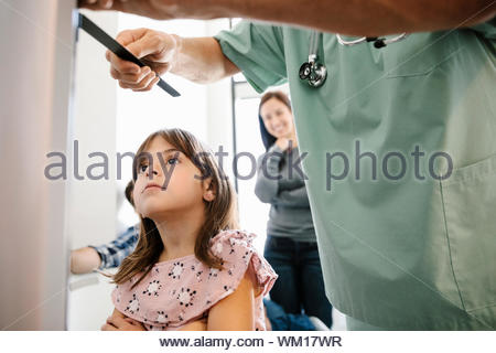 Nurse measuring height of girl in hospital Stock Photo - Alamy