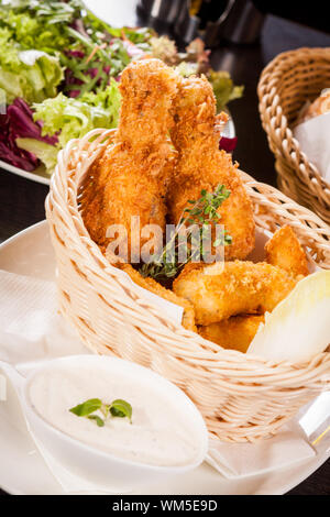 Golden fried chicken legs on beige plate with red cherry tomatoes ...