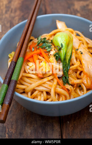 hand pulled stretched Chinese ramen noodles on a bowl with chopstick ...