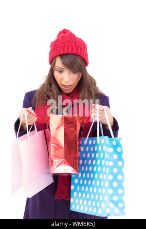 Shocked brunette opening gift bag on white background Stock Photo - Alamy
