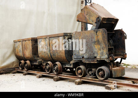 Old and rusty mine machine and train with wagons in mine shaft with ...