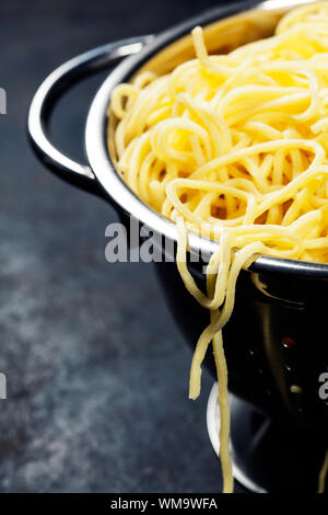 spaghetti in colander on dark vintage background Stock Photo - Alamy