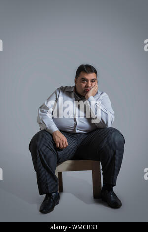 Overweight man sitting on chair in a bar, rear view Stock Photo - Alamy