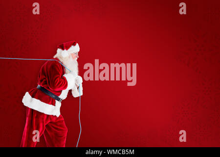 Santa claus pulling rope against pink vignette Stock Photo - Alamy