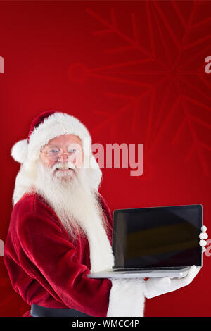 Santa Claus presents a laptop against red background Stock Photo - Alamy
