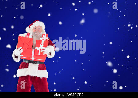 Santa carries a few presents against red background Stock Photo - Alamy