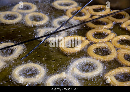 Turkish Dessert Churros Halka Tatli frying in hot oil. Turkish ...
