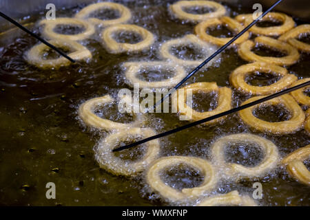 Turkish Dessert Churros Halka Tatli frying in hot oil. Turkish ...