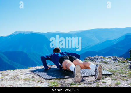 Handsome young bodybuilder laying down on the floor, showing ripped abs ...