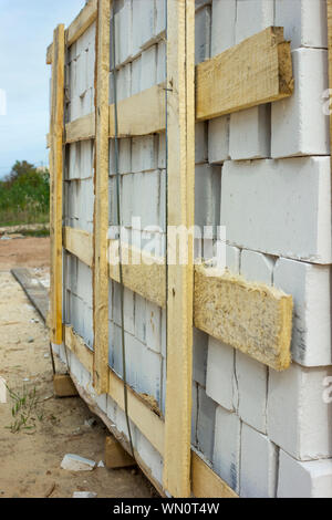 Workers build a stone wall at a site Stock Photo - Alamy