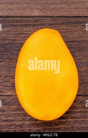 Fresh mango,beautiful chopped fruit with green leaves on dark wooden ...