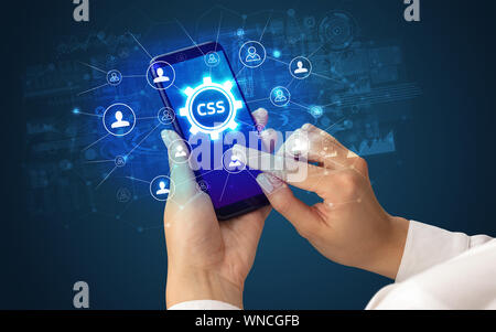 Female hand holding smartphone with CSS abbreviation, modern technology ...