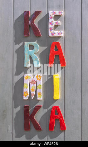 Multi-colored ceramic tiles on wall above Black Aga oven in traditional ...