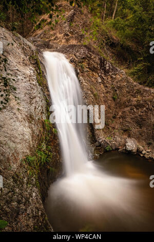 A long exposure shot of a small waterfall full of rocks in the daylight ...