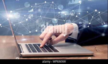 Businessman typing on laptop with linked reports charts grapghs around ...