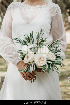 Bridal bouquet of white peony roses and wedding rings nearby. Wedding ...