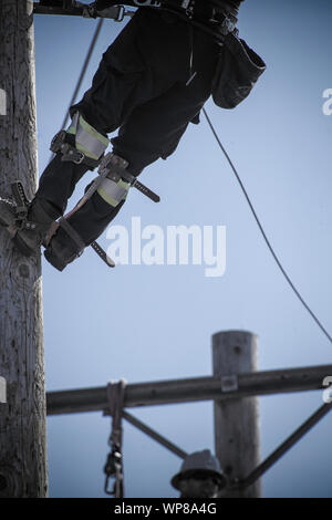 Electrician lineman at climbing work on electrical power pole Stock ...