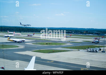 Airplanes lining up for take-off whilst a plane lands on runway Stock ...